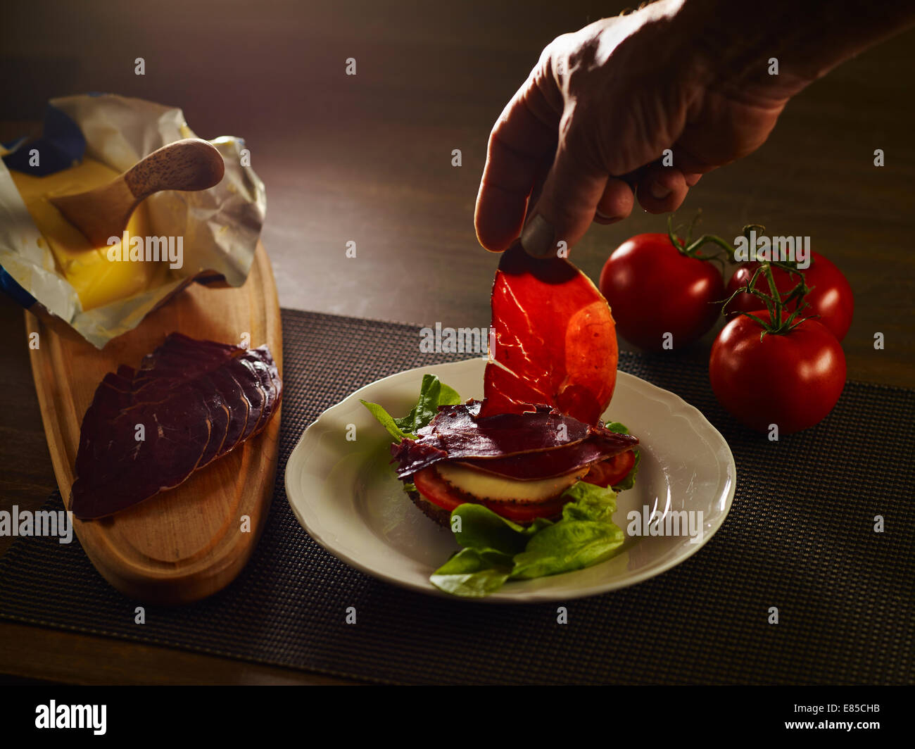 Morning, a man making a snack, cold-smoked reindeer meat and vegetables ...