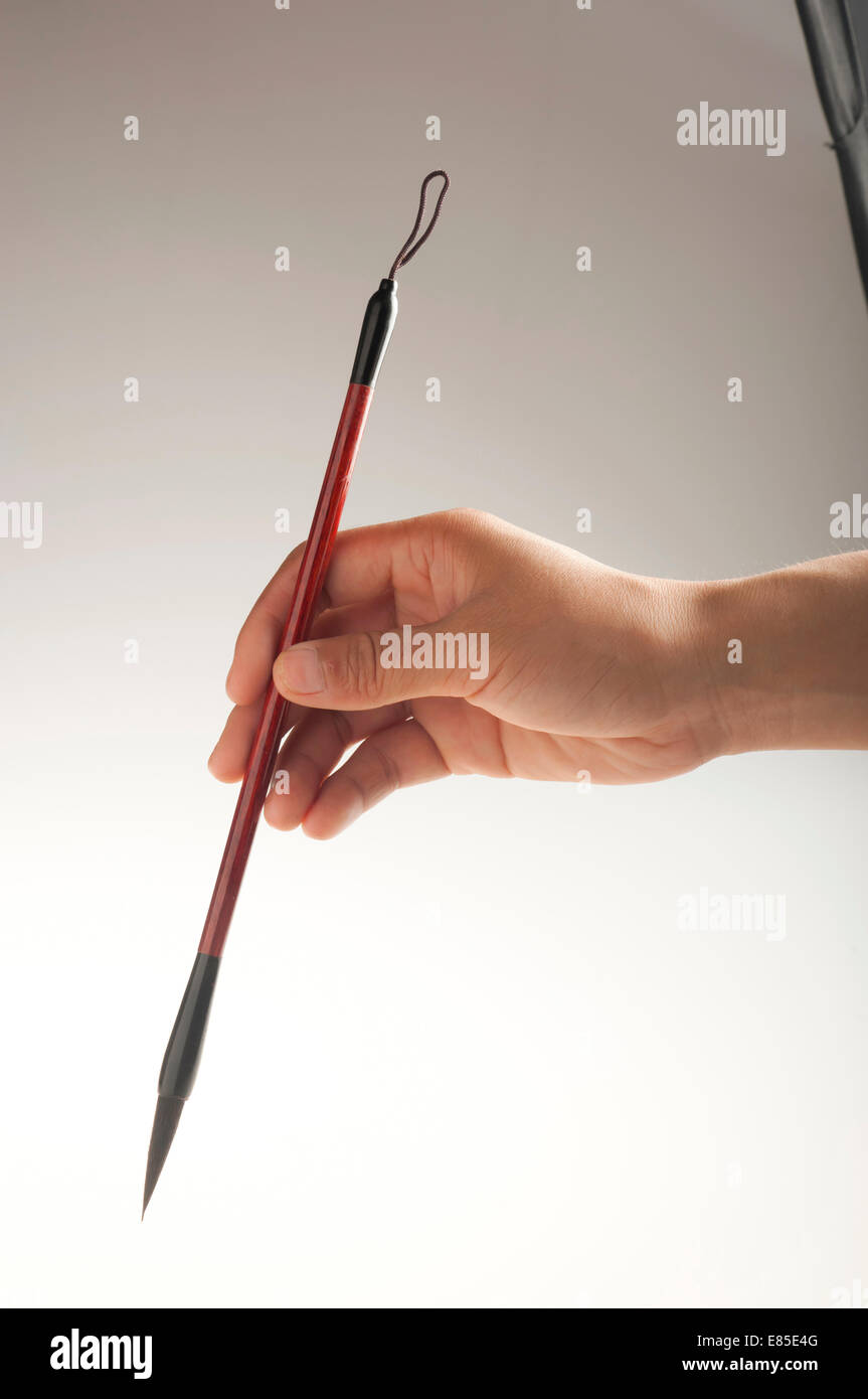 Hand holding traditional writing brush hi-res stock photography and ...