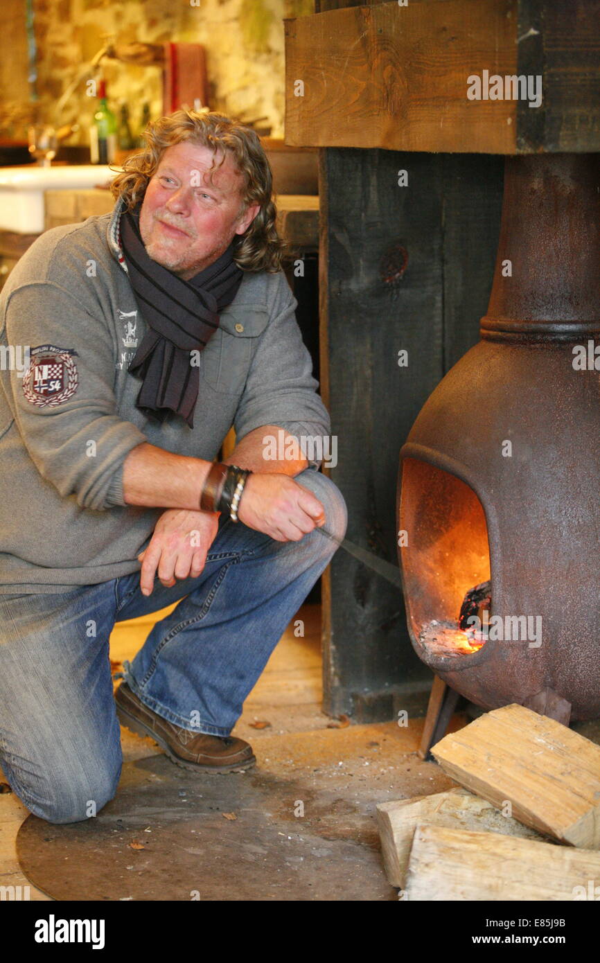A man stoking a fire Stock Photo - Alamy
