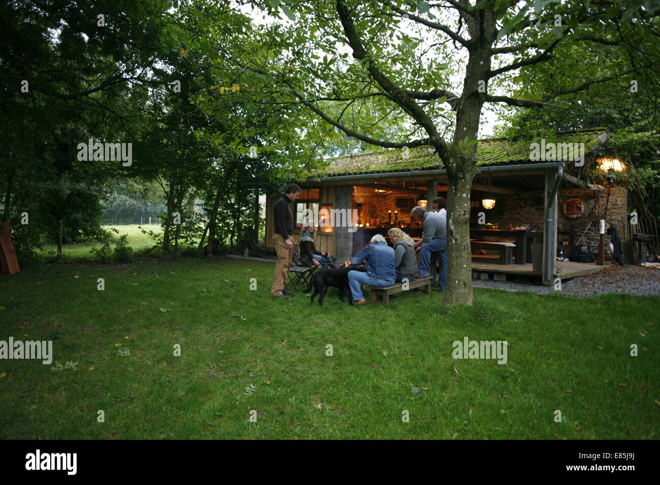 People relaxing outside a converted barn Stock Photo - Alamy