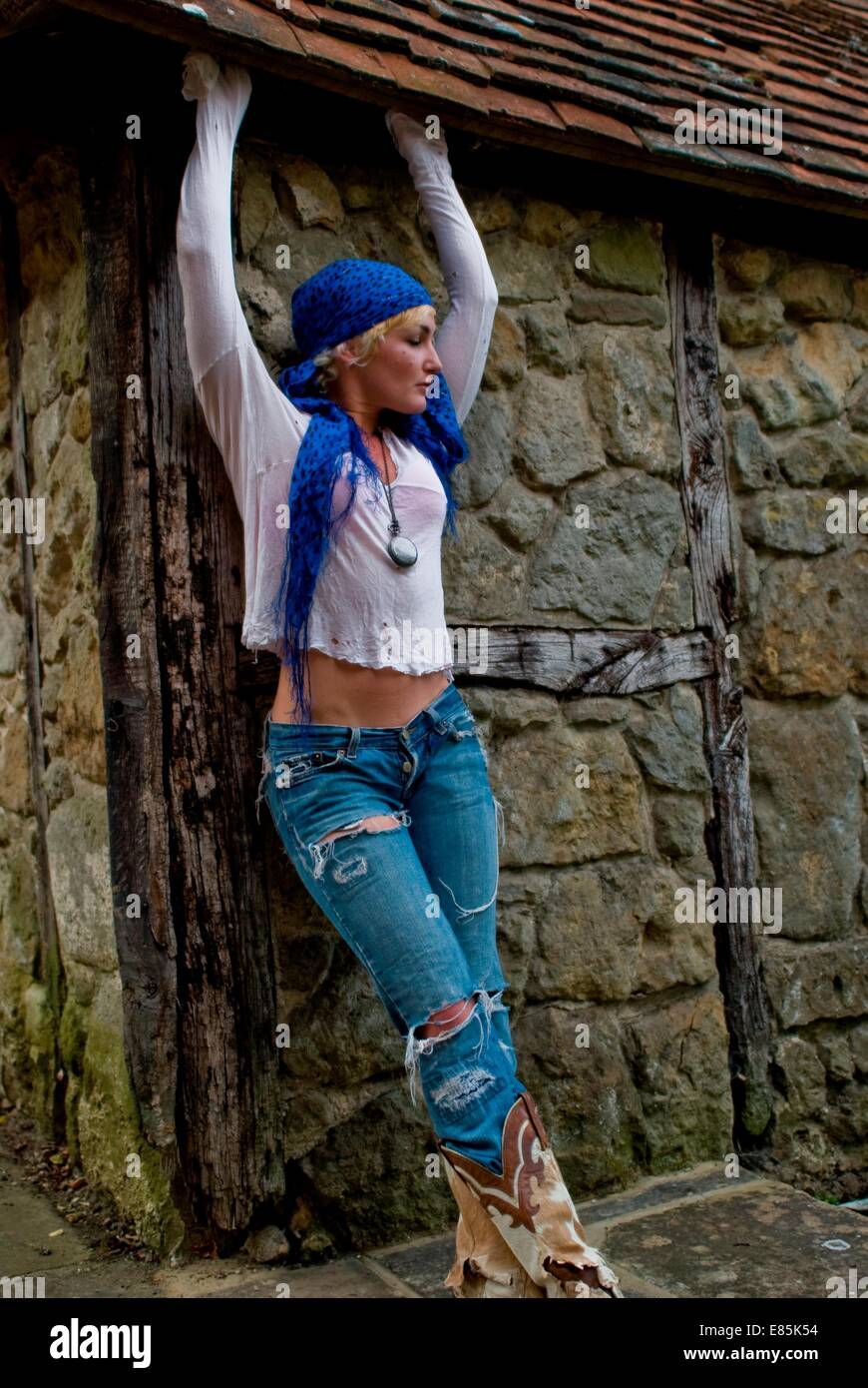 Woman in ripped clothing with blue headscarf Stock Photo - Alamy