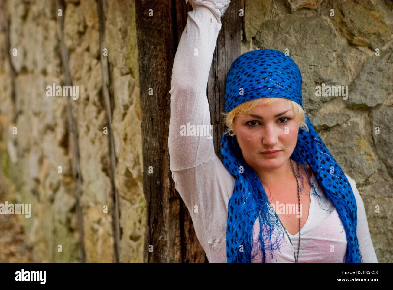 Woman in ripped clothing with blue headscarf Stock Photo - Alamy