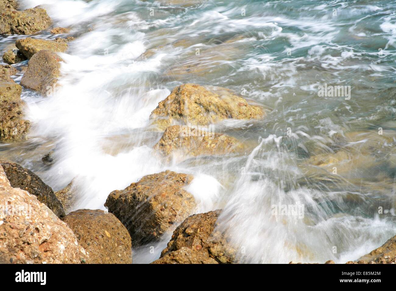 The rock on seashore with water and coming wave (long exposure Stock ...