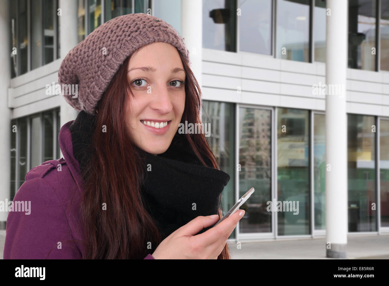 Young woman in winter making a call with a smartphone or mobile phone ...