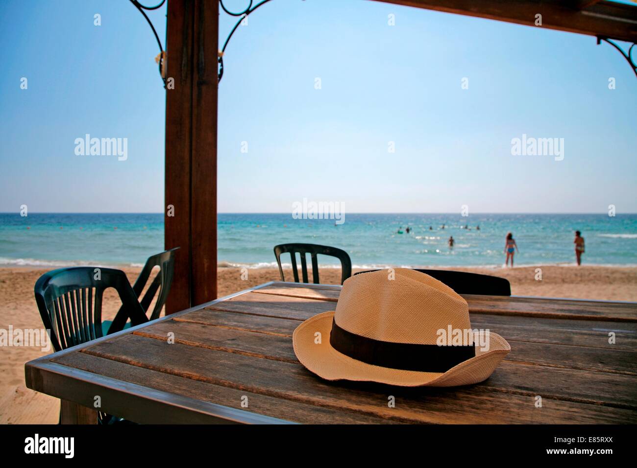 Hat on a tables at beach Stock Photo - Alamy