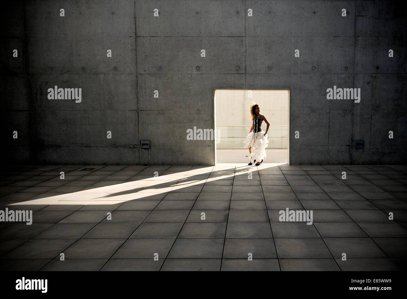 Woman standing in a doorway casting a shadow Stock Photo - Alamy
