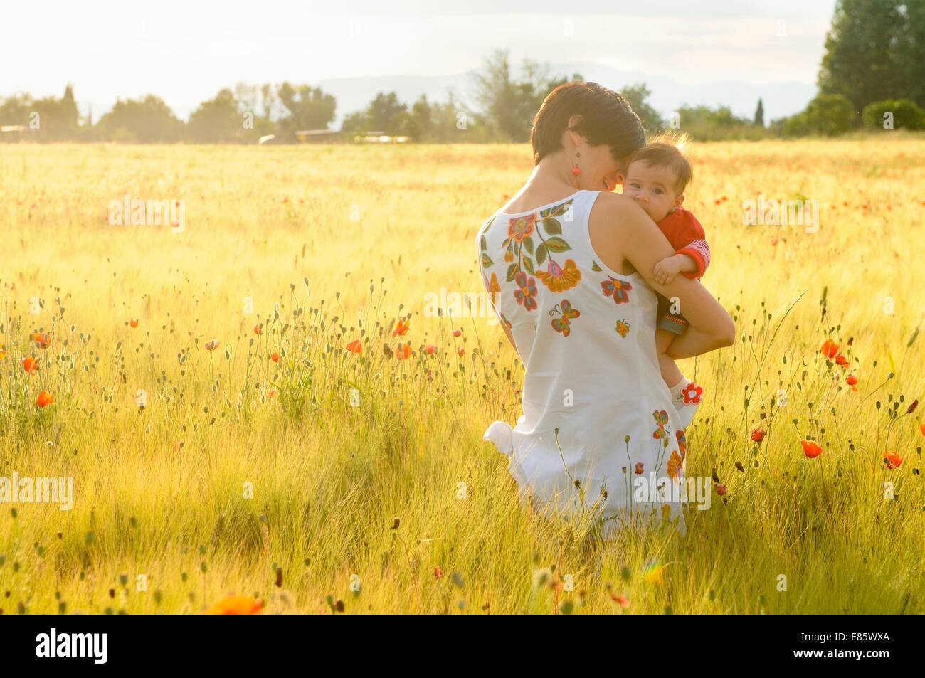 Mum and baby in a poppy field Stock Photo - Alamy