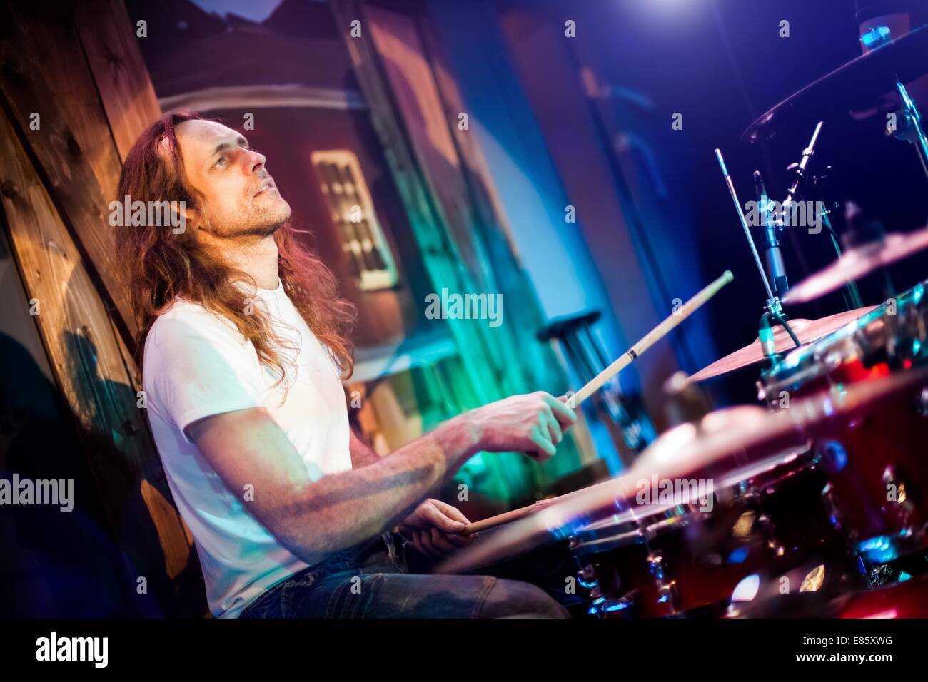 musician playing drums on a red background Stock Photo - Alamy