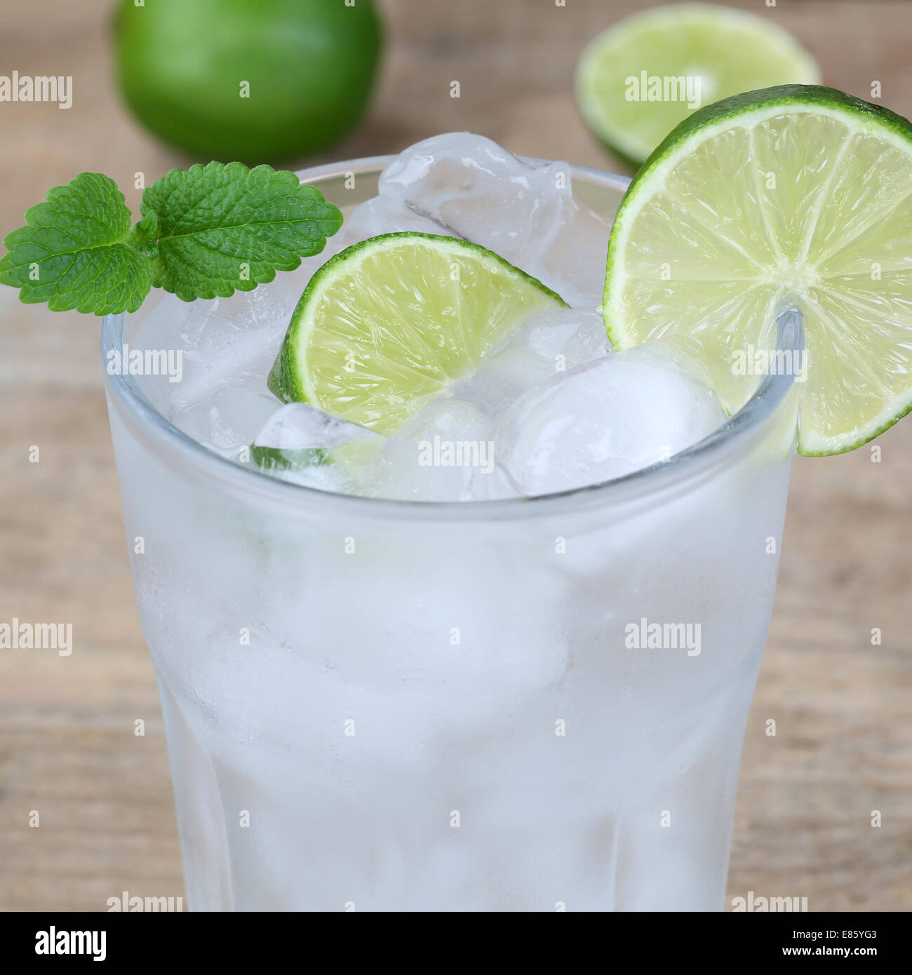 Cold sparkling water drink with ice cubes and limes Stock Photo - Alamy