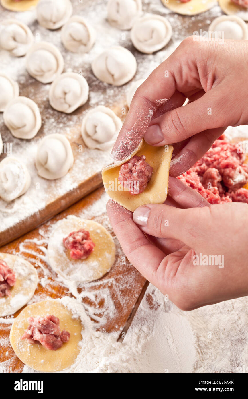 Dumplings. Dough with meat filling on the cook's hands Stock Photo - Alamy