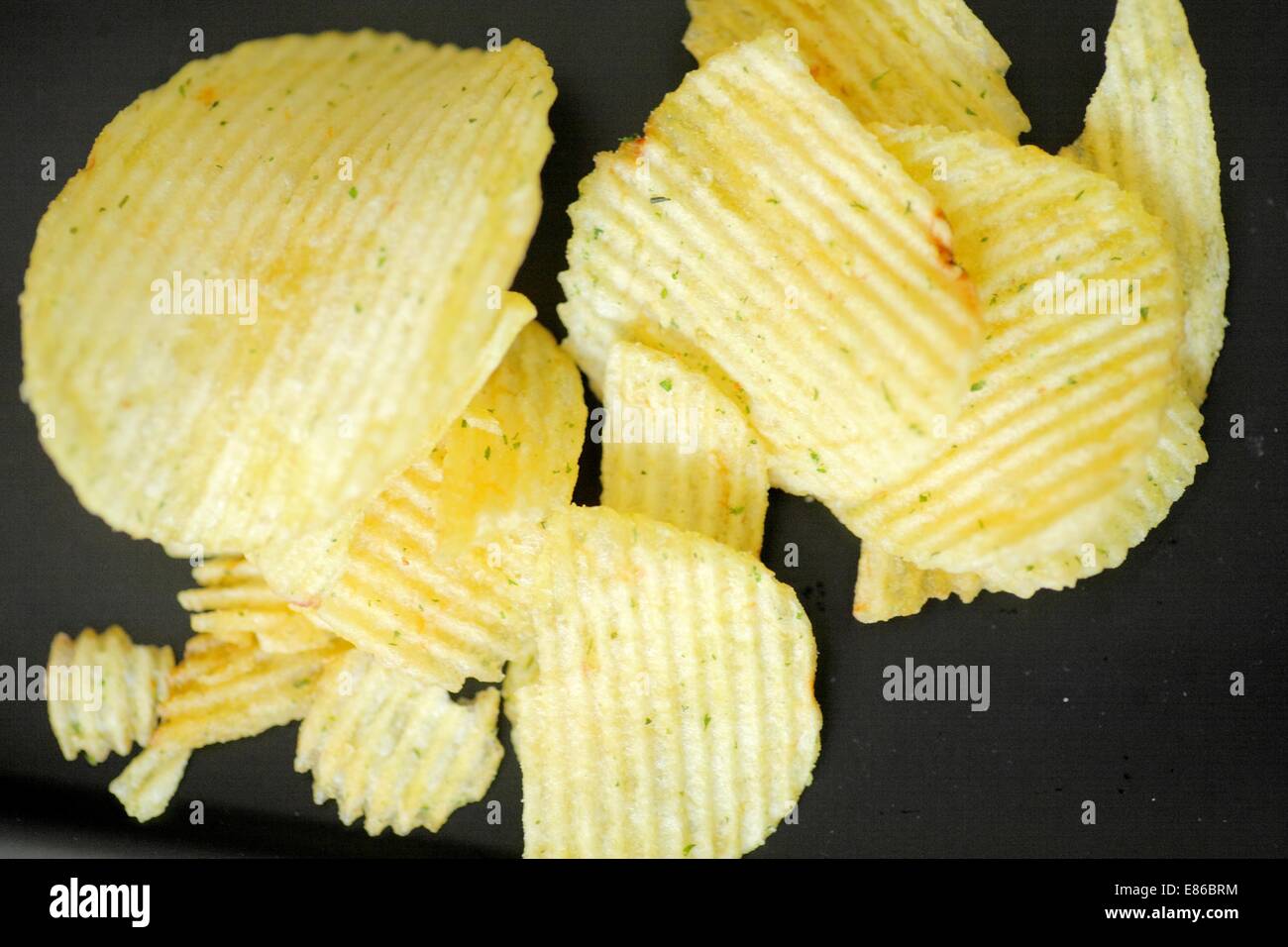 yellow potato chips closeup on black background Stock Photo - Alamy