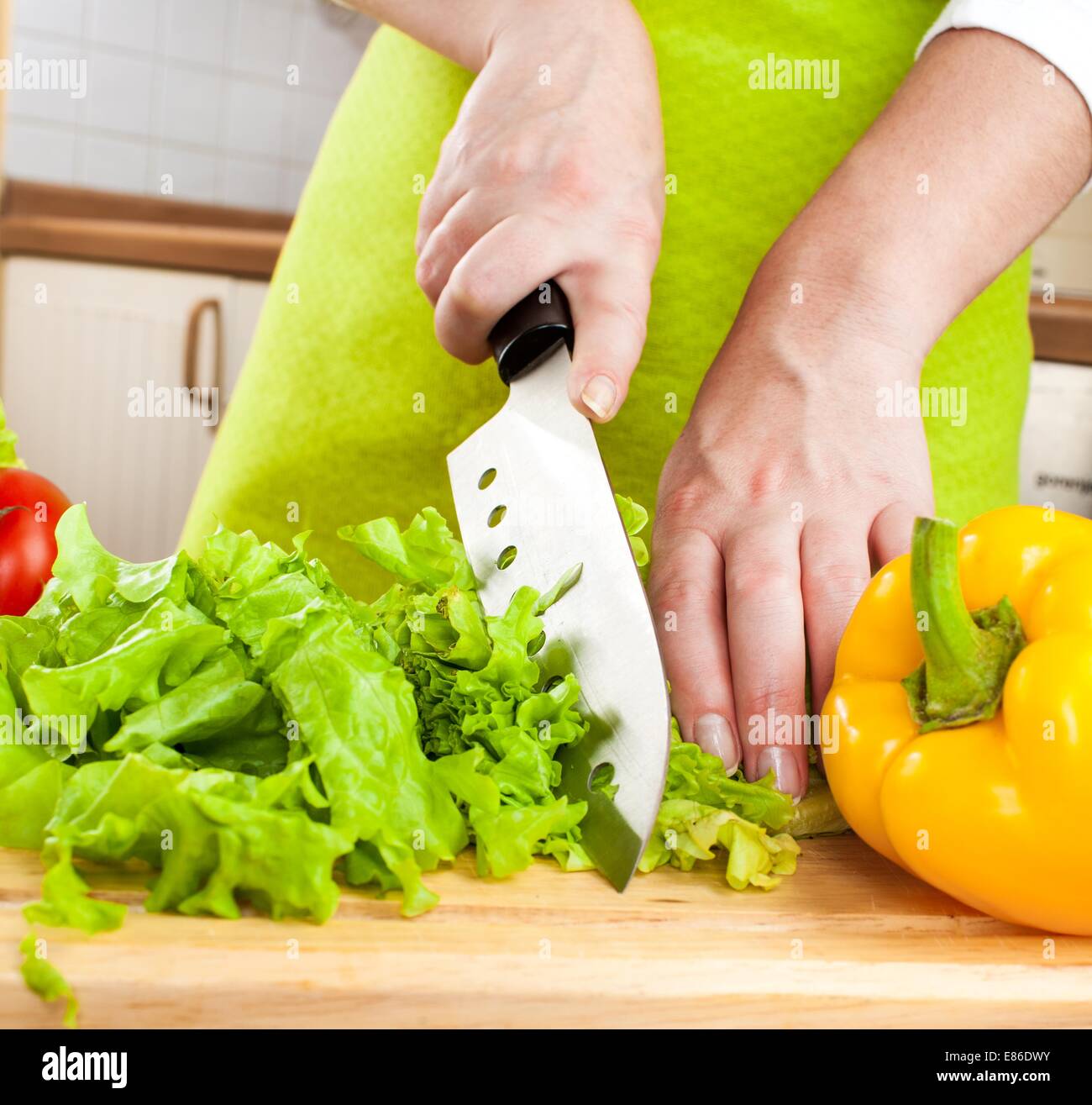Woman's hands cutting lettuce, behind fresh vegetables Stock Photo - Alamy
