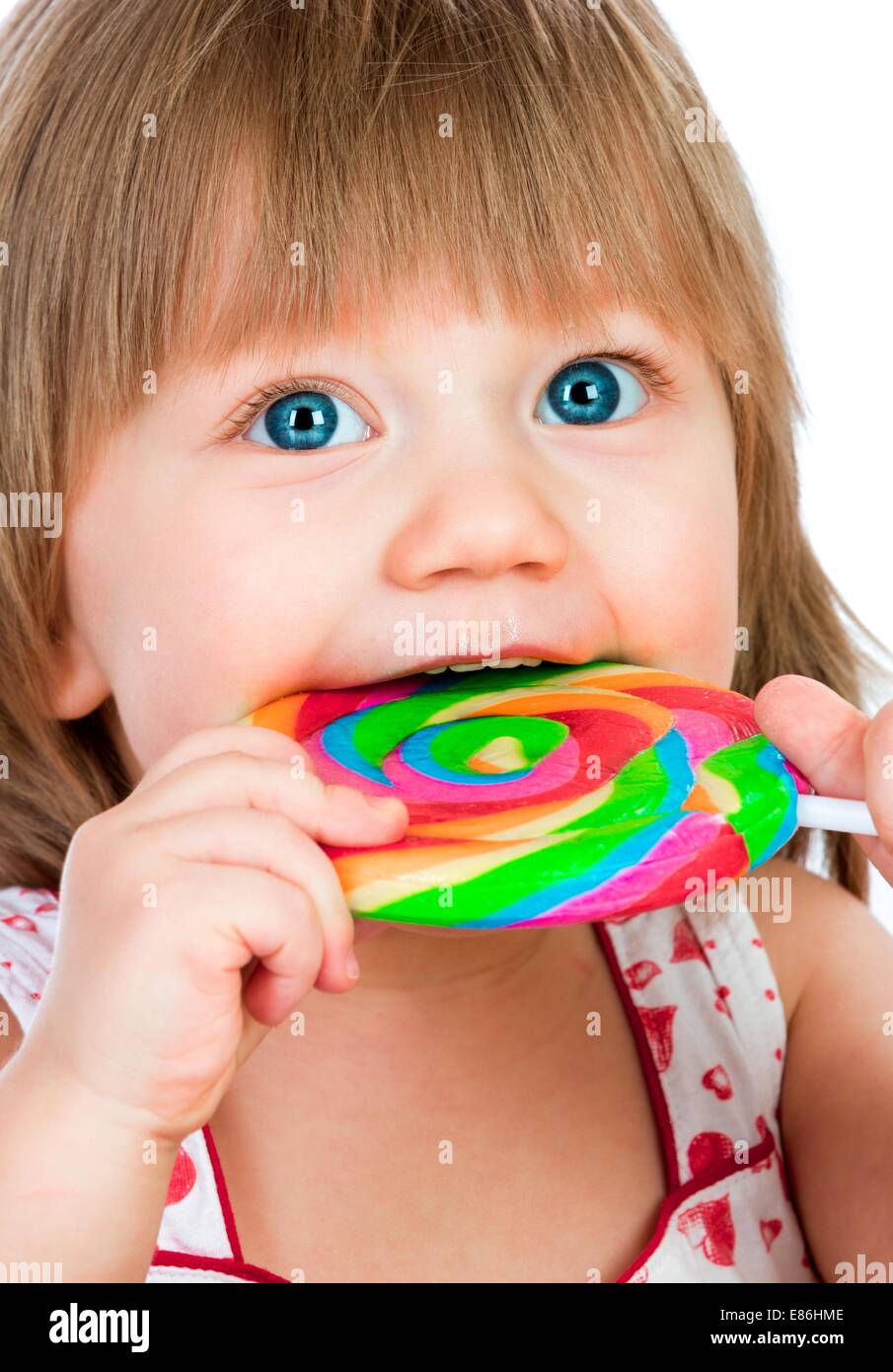 Baby girl eating a sticky lollipop on white background Stock Photo - Alamy