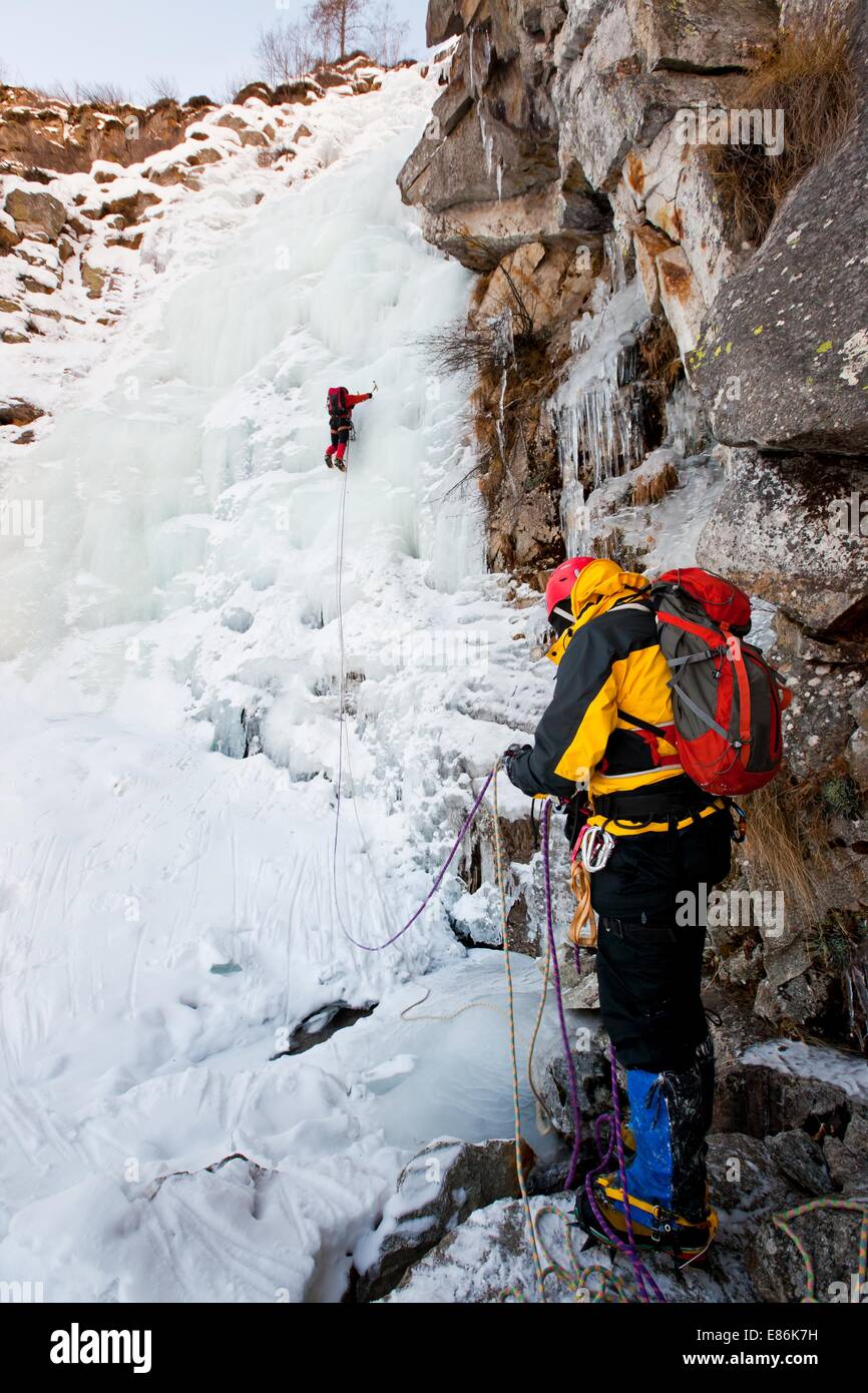 Ice climbing on a steep ice fall; vertical frame; west Alps, Italy ...