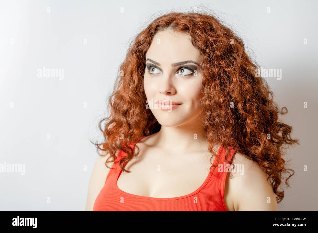 curly hair brunette on white background weared orange red shirt ...