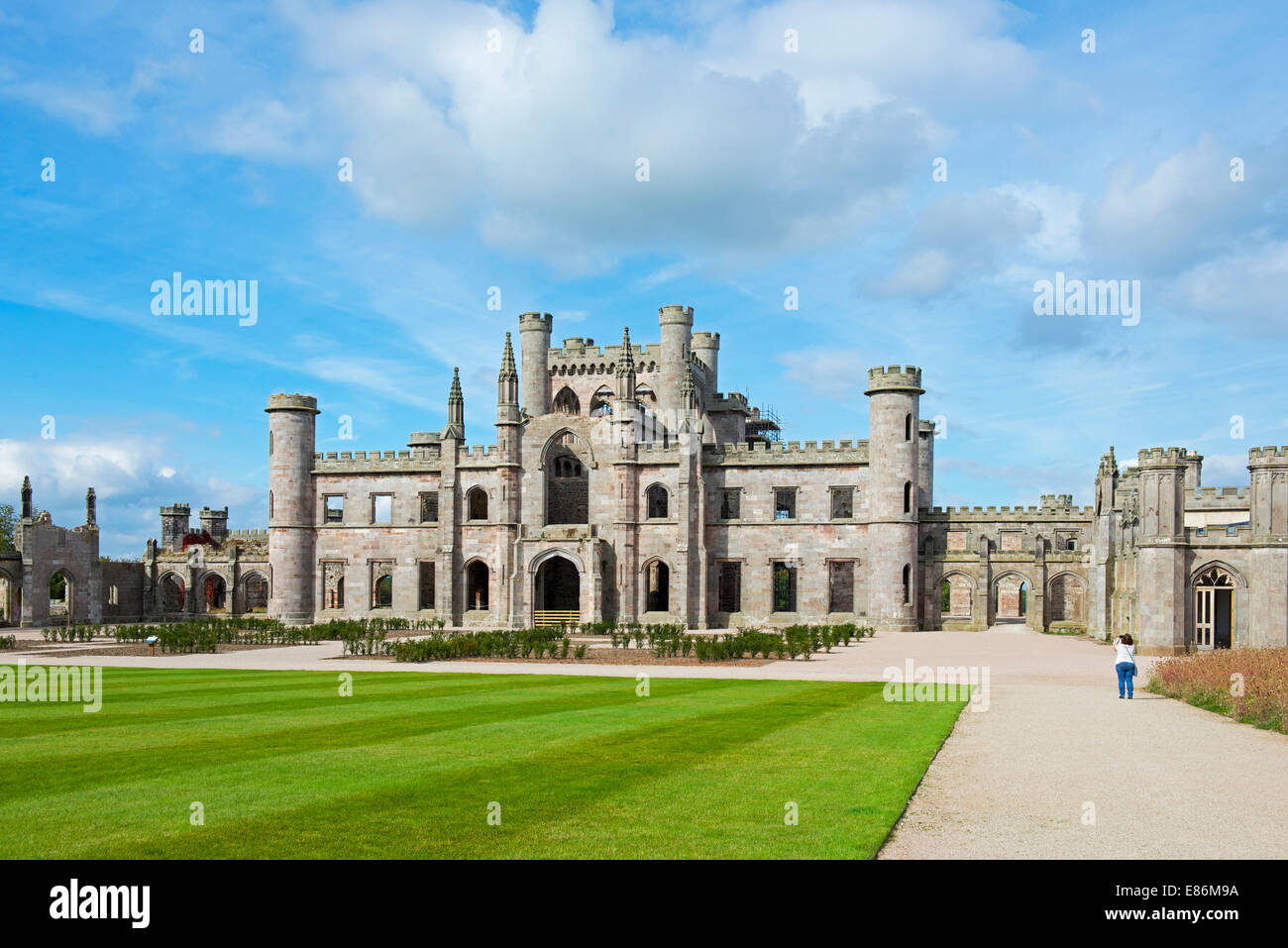 Woman photographing the ruins of Lowther Hall, near Penrith, Cumbria ...