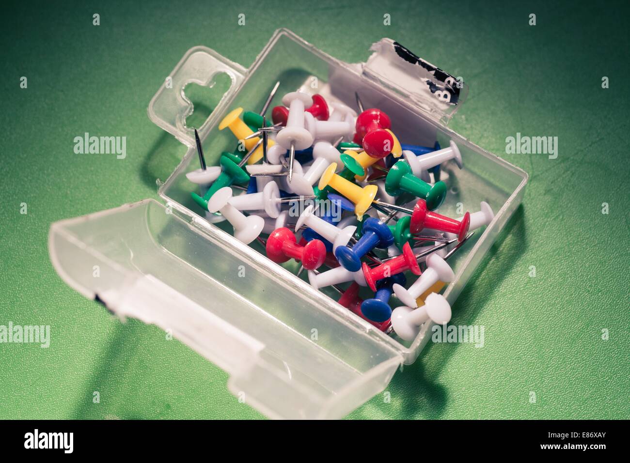 toned image of mixed colors office push-pins in the plastic pack, angle ...