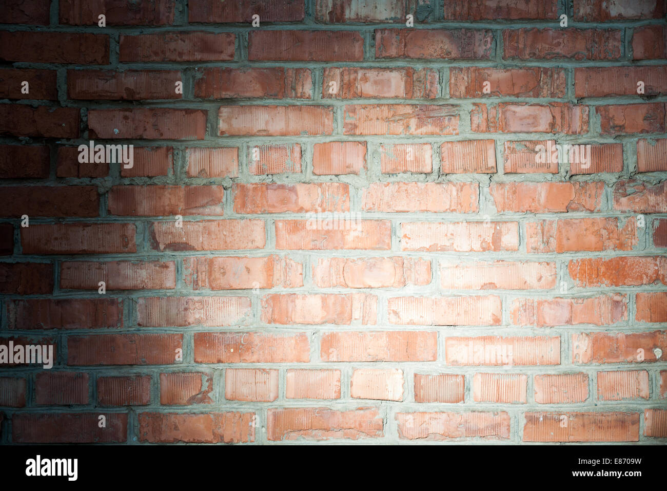 red brick wall and spot of light on, vignette Stock Photo - Alamy