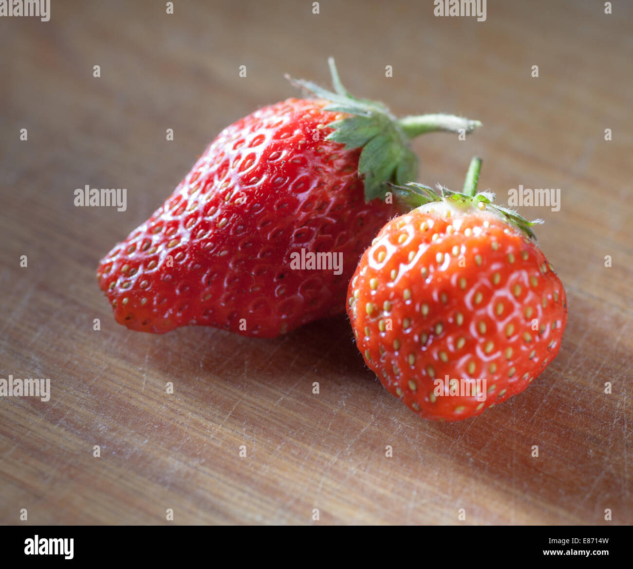 two strawberryes on the wooden plank Stock Photo - Alamy