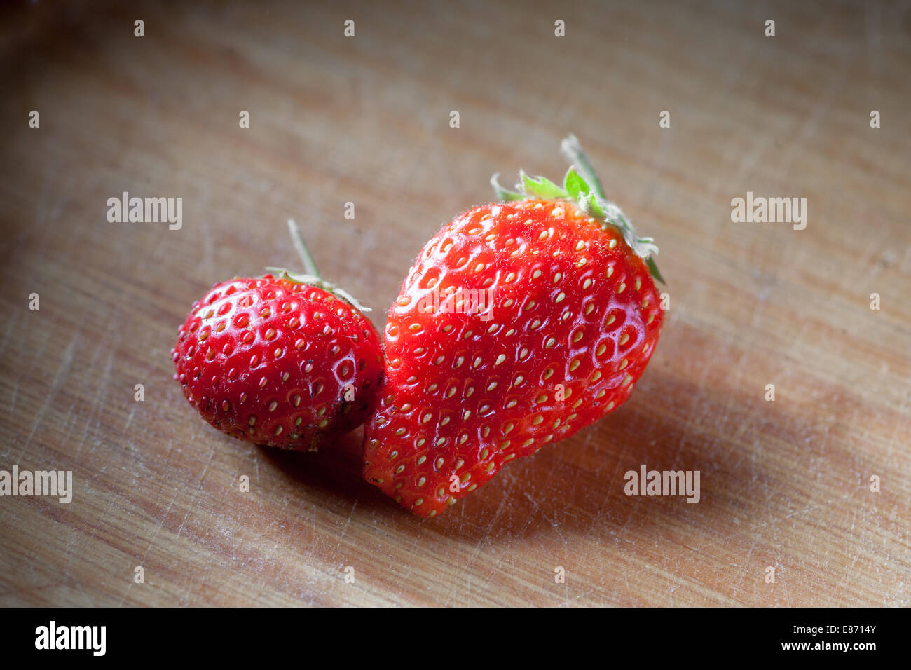 two strawberryes on the wooden plank Stock Photo - Alamy
