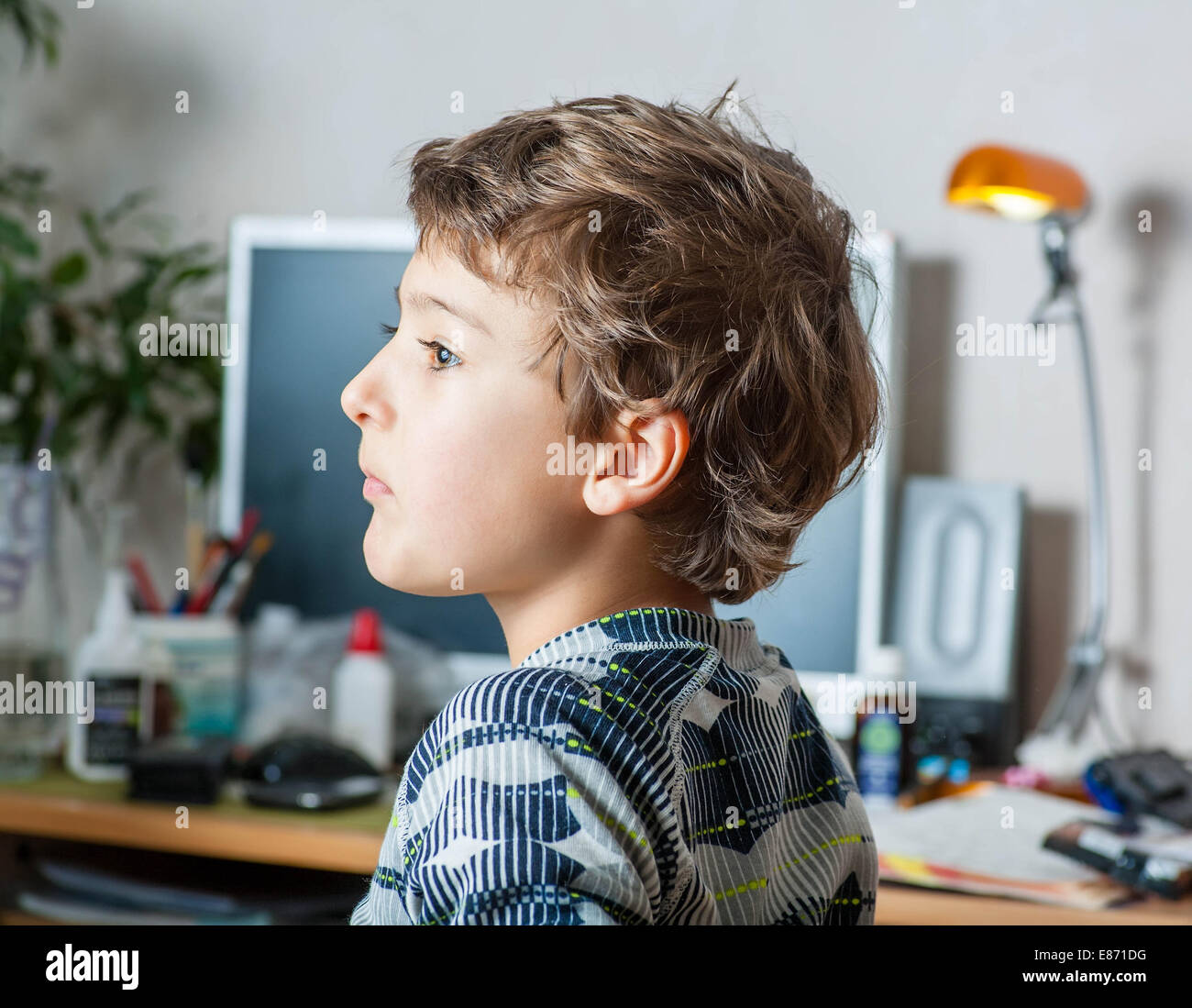 Side view of a little boy at table in the room Stock Photo - Alamy