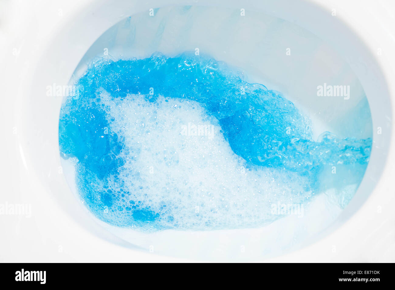 Toilet bowl with blue water flowing Stock Photo - Alamy