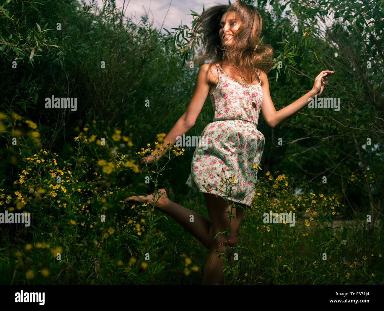 Cute female summertime dance. Happy girl dancing outdoors in grass and ...