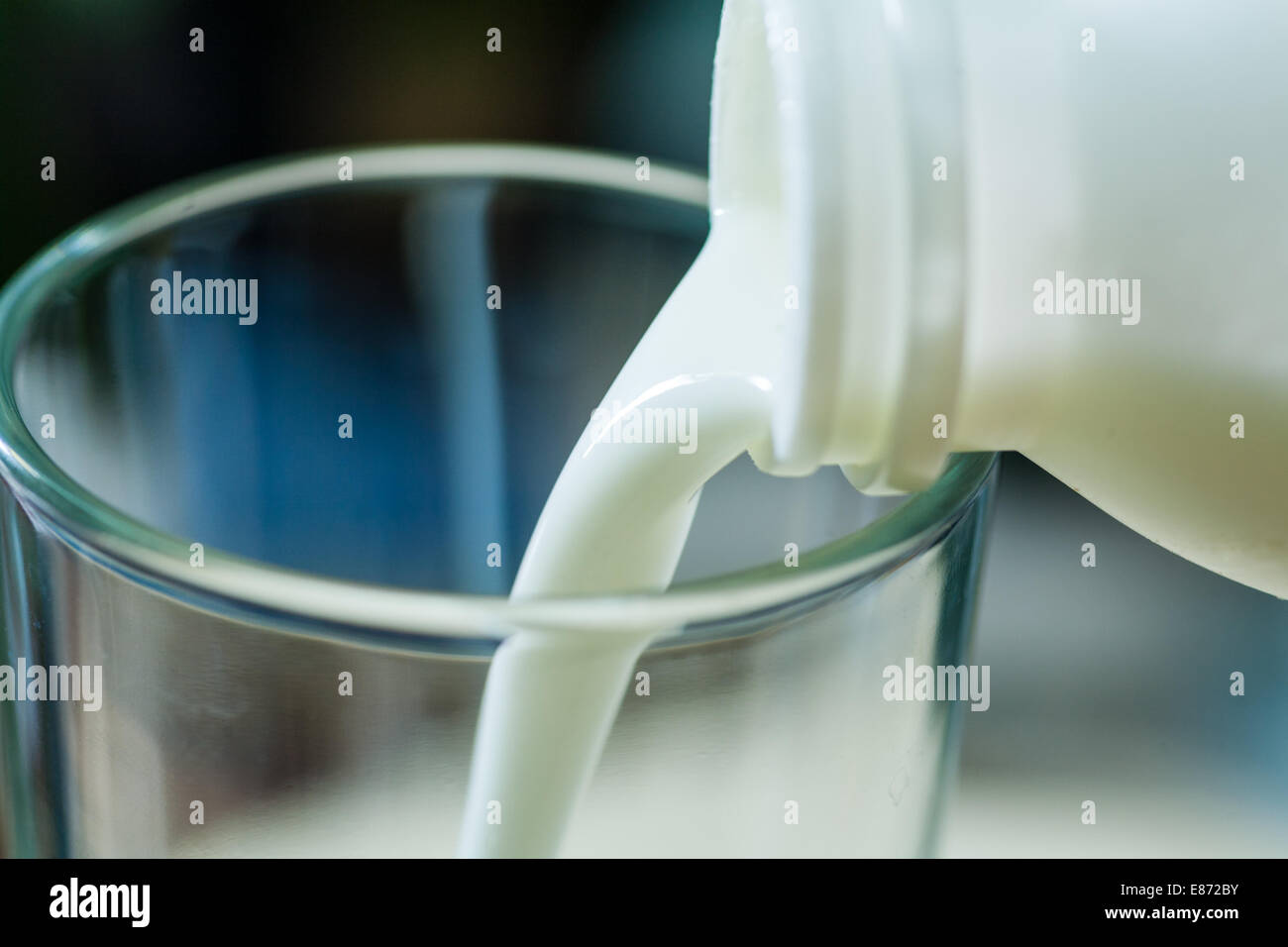 Fresh milk poured in glass cup over indoors background Stock Photo - Alamy