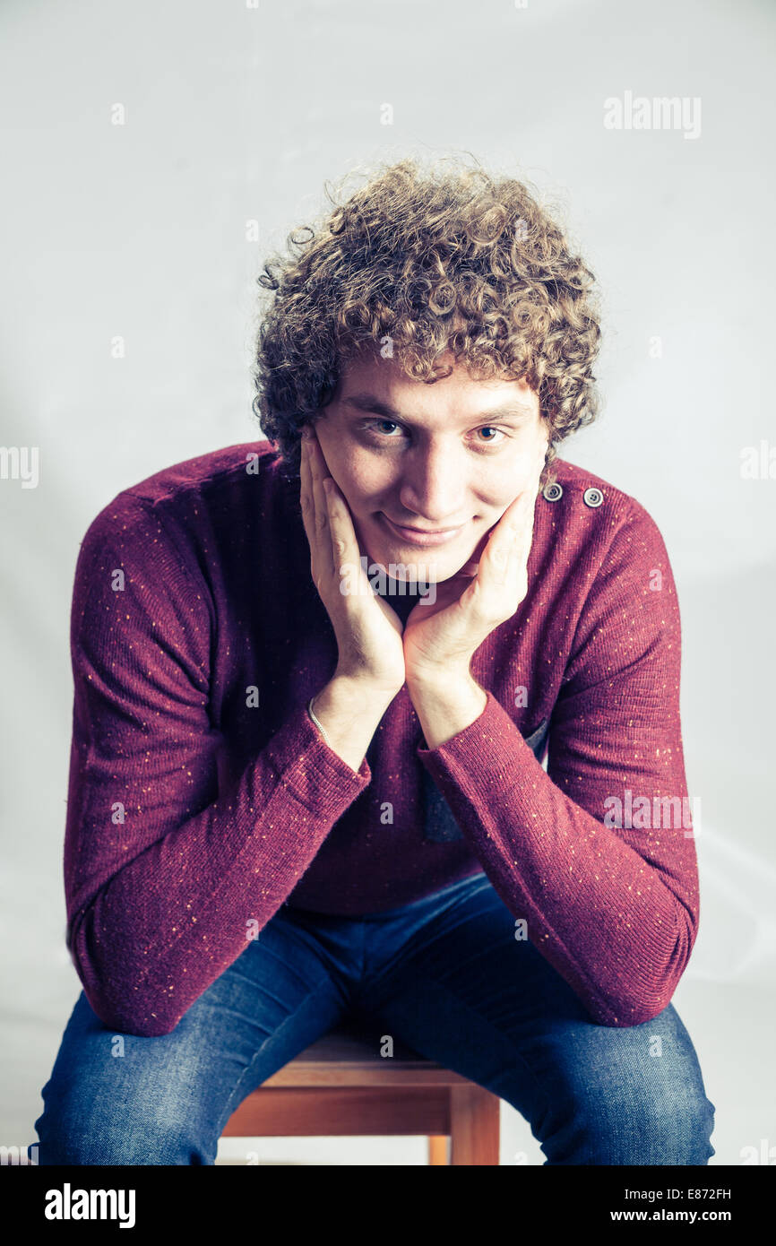 Man weared violet pullover. Curly white man in studio sitting Stock ...
