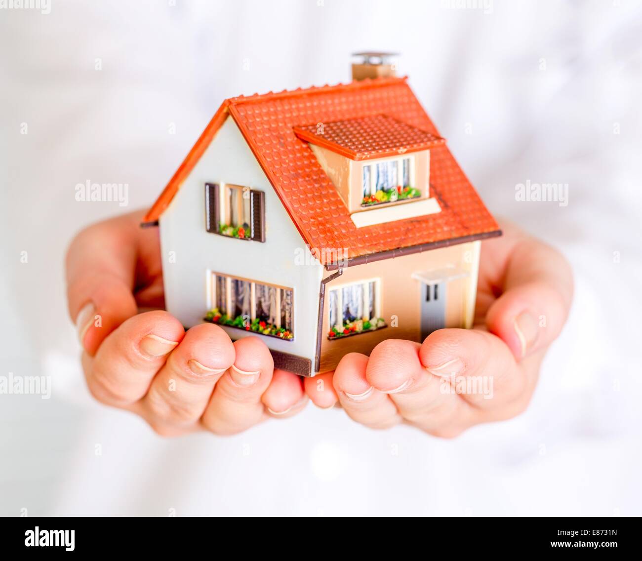 house in human hands on a white background Stock Photo - Alamy