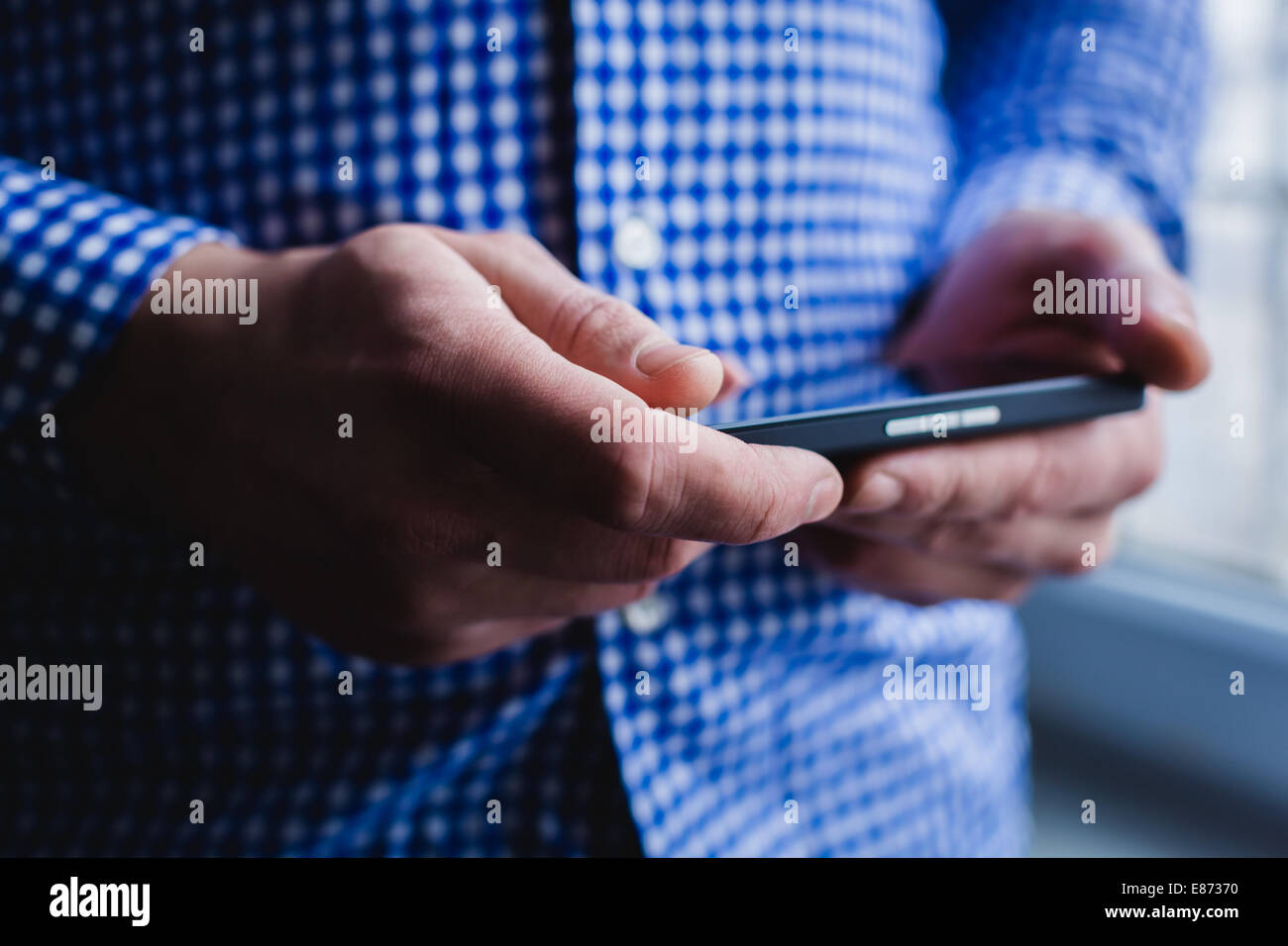 The man is using a smartphone. Modern mobile phone in hand Stock Photo ...