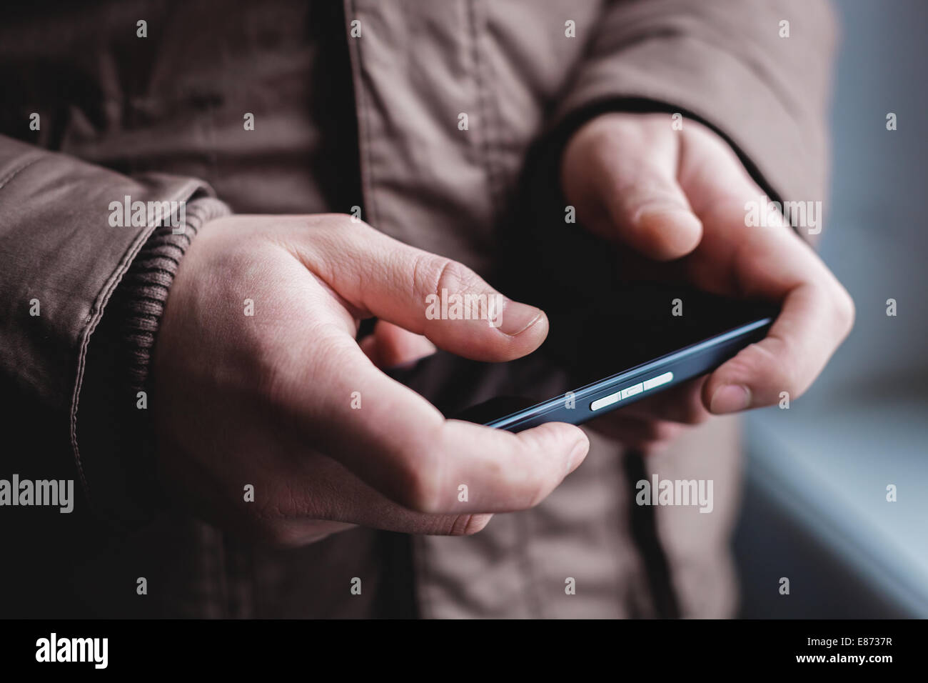 The man is using a smartphone. Modern mobile phone in hand Stock Photo ...