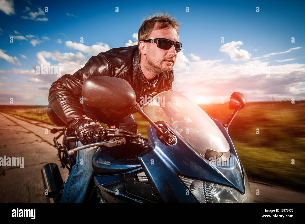 Biker in helmet and leather jacket racing on the road Stock Photo - Alamy