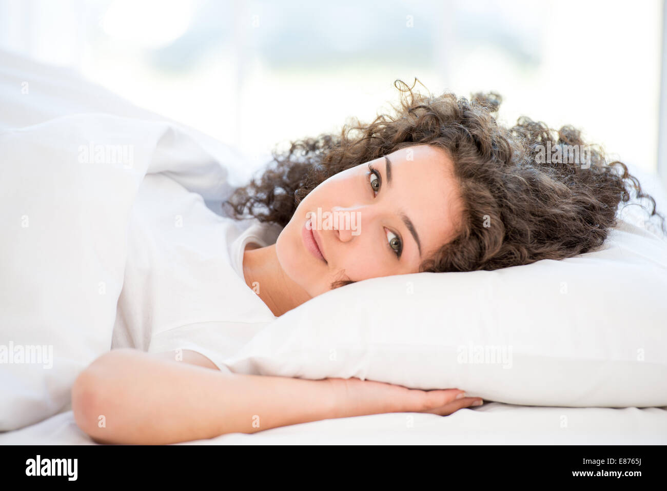 Beautiful young woman waking up Stock Photo - Alamy