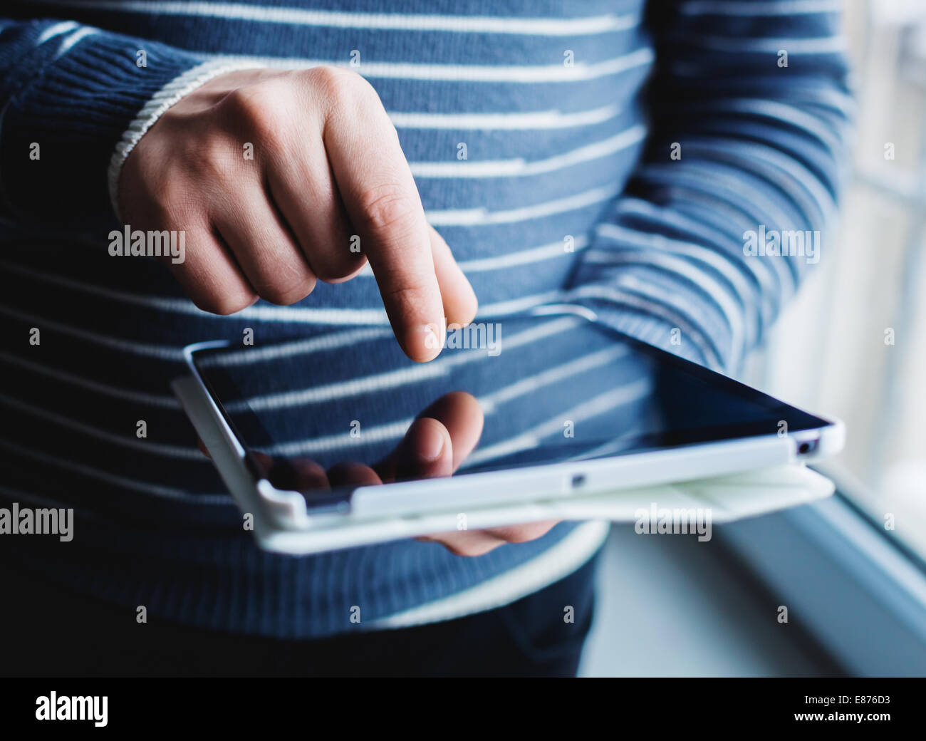 The man uses a tablet PC. Modern gadget in hand Stock Photo - Alamy
