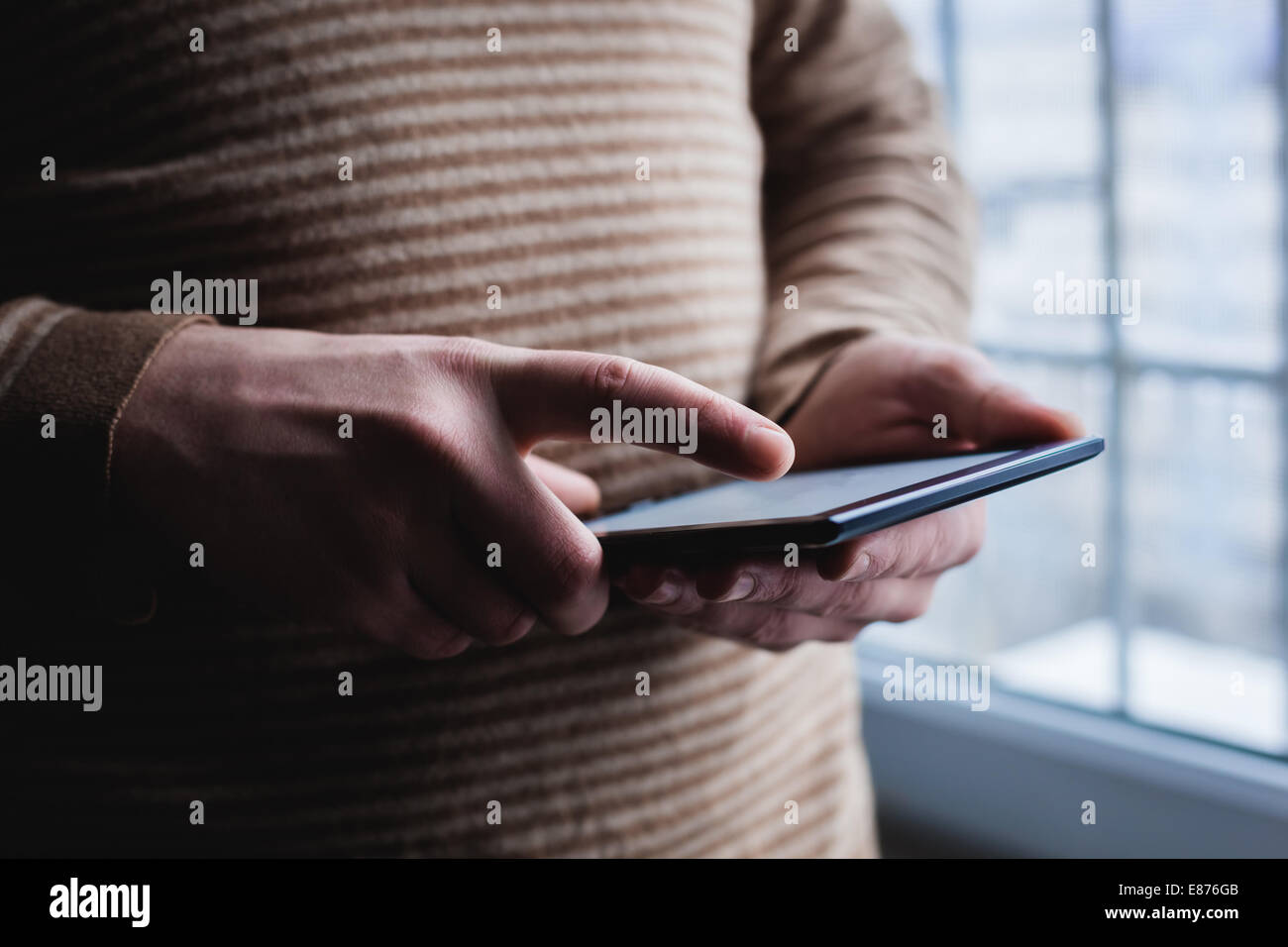 The man uses a tablet PC. Modern gadget in hand Stock Photo - Alamy