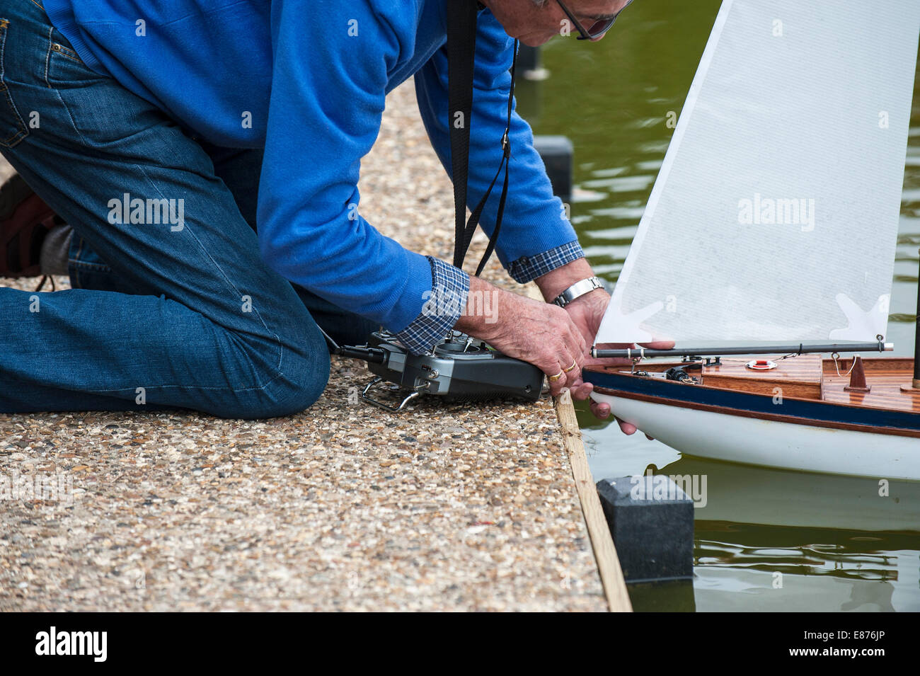 A close up view of a model boat enthusiast launching his model yacht on ...