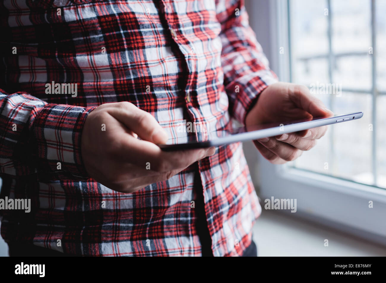 The man uses a tablet PC. Modern gadget in hand Stock Photo - Alamy