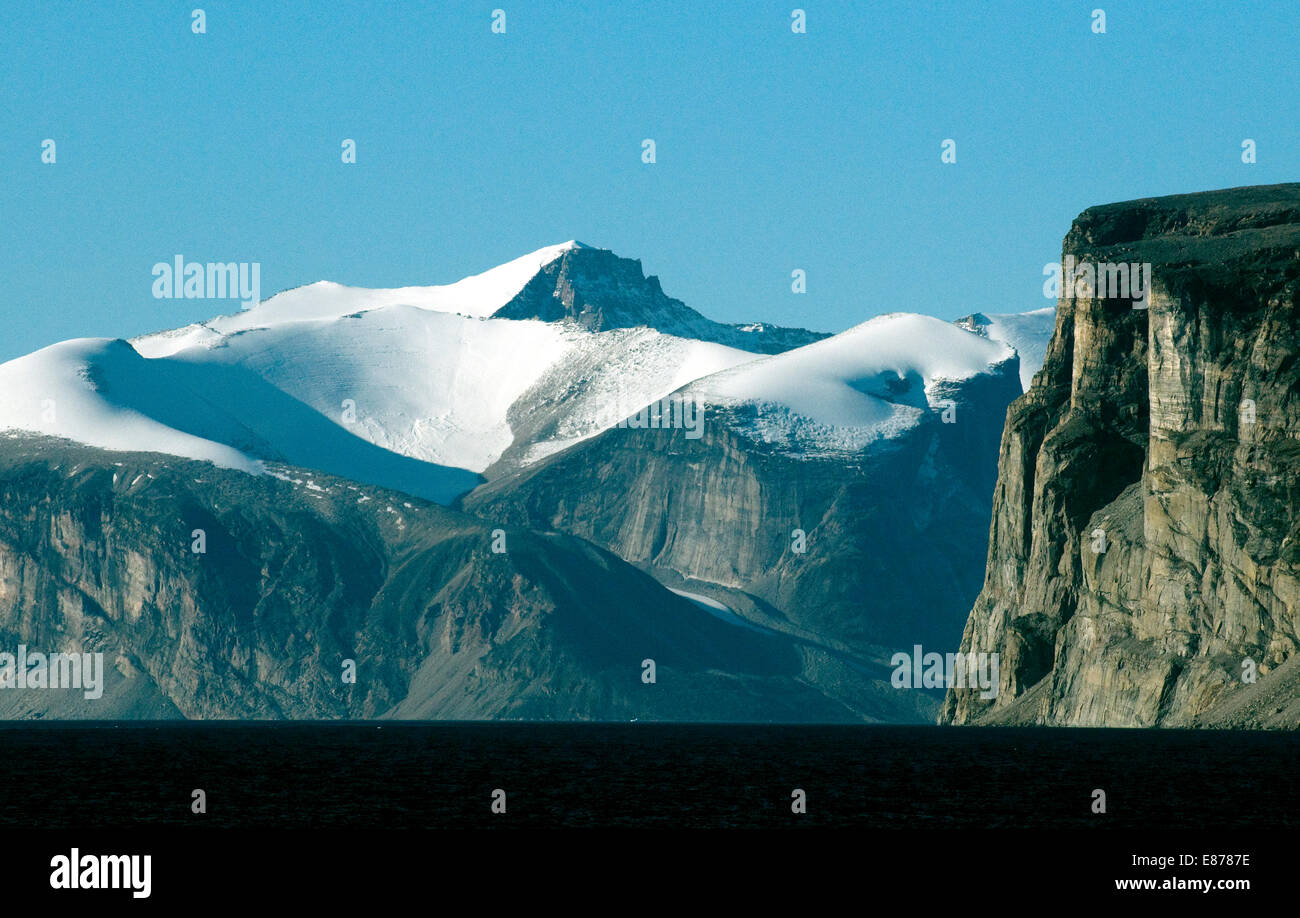 Stark cliff contrasts with snowcapped mountain in a spectacular glimpse ...