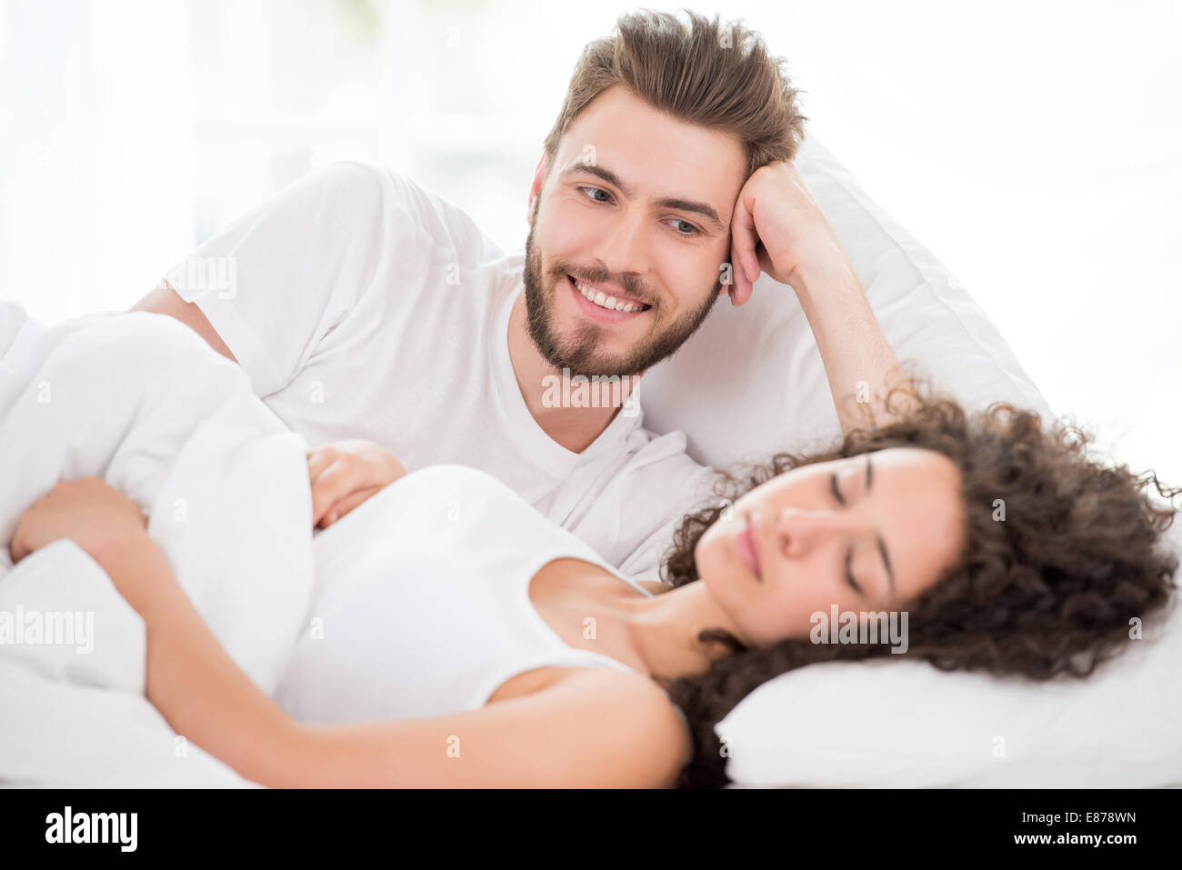 Happy husband admiring his sleeping wife Stock Photo - Alamy