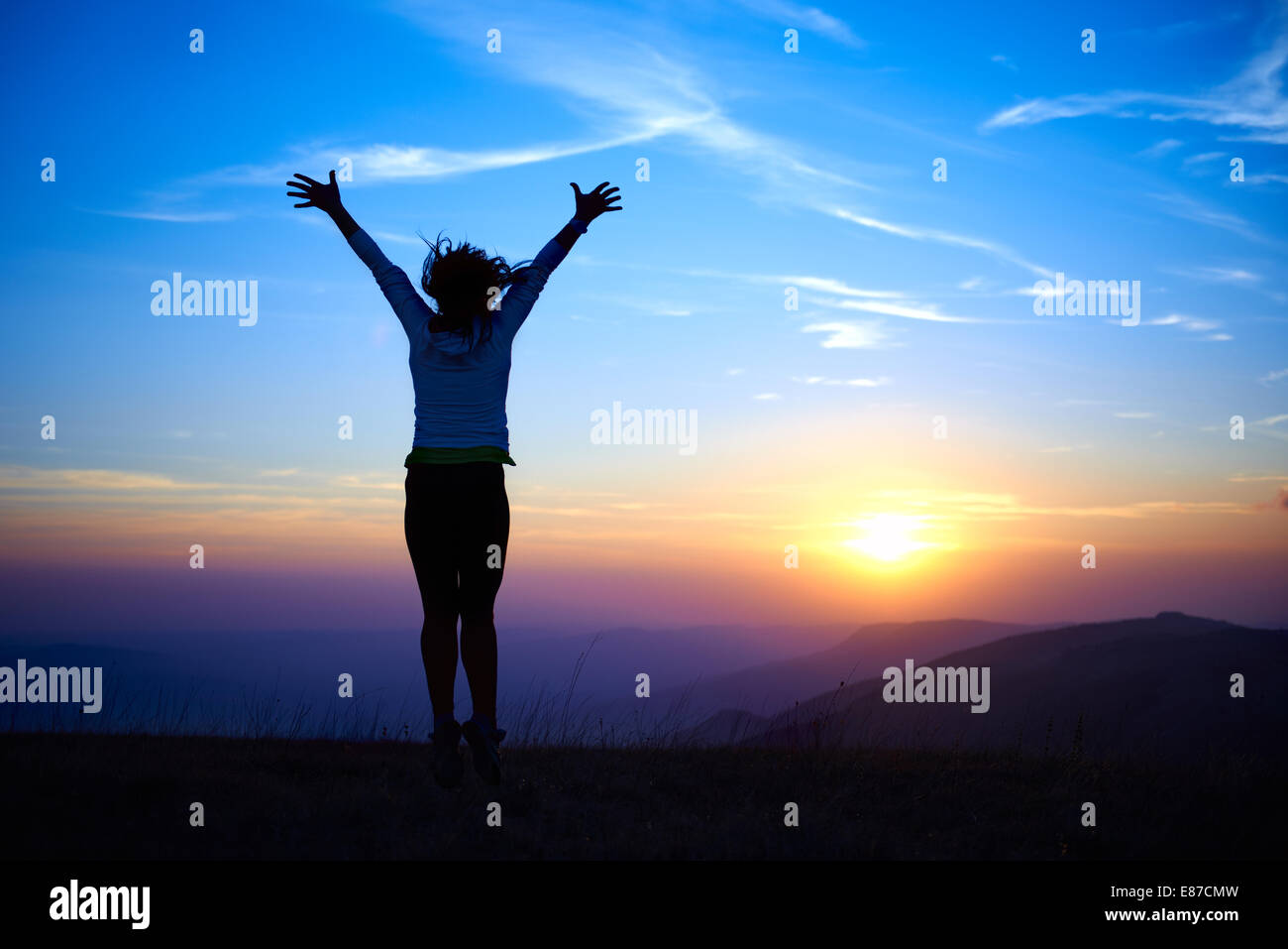 Silhouette of young woman jumping against sunset Stock Photo - Alamy