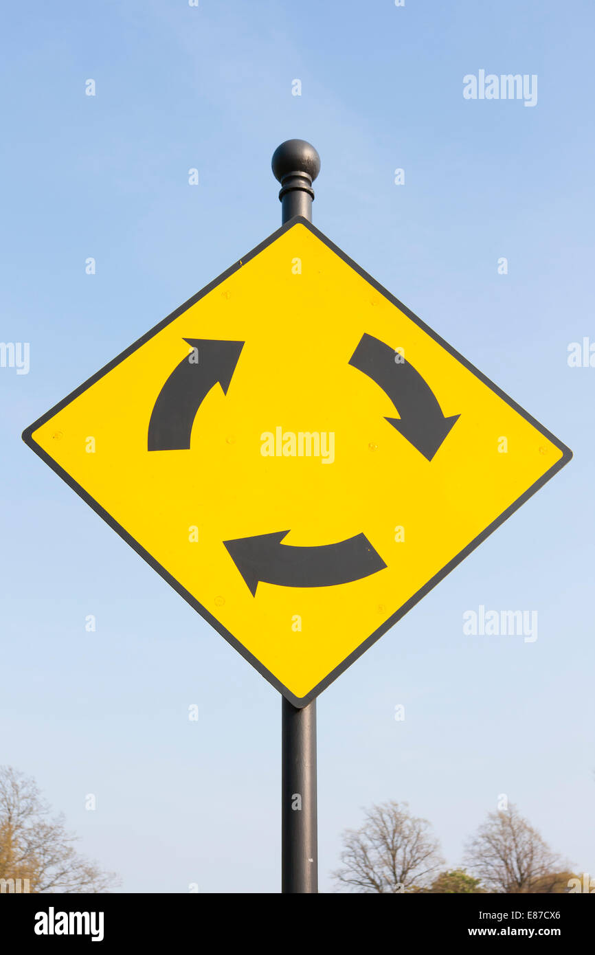 Yellow Roundabout sign against blue sky Stock Photo - Alamy