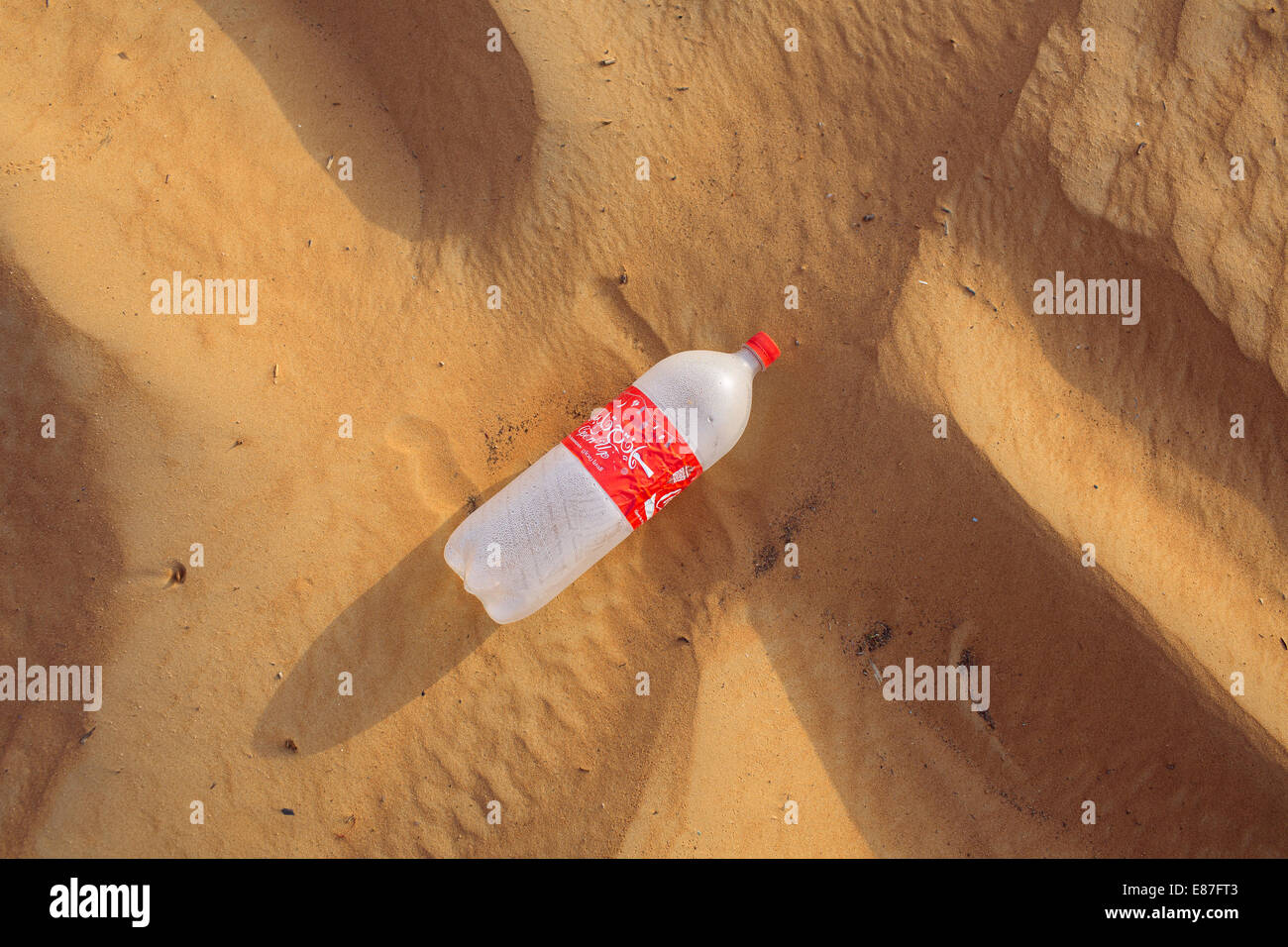 Empty plastic coke bottle wastes pollution in a desert in Dubai, UAE ...