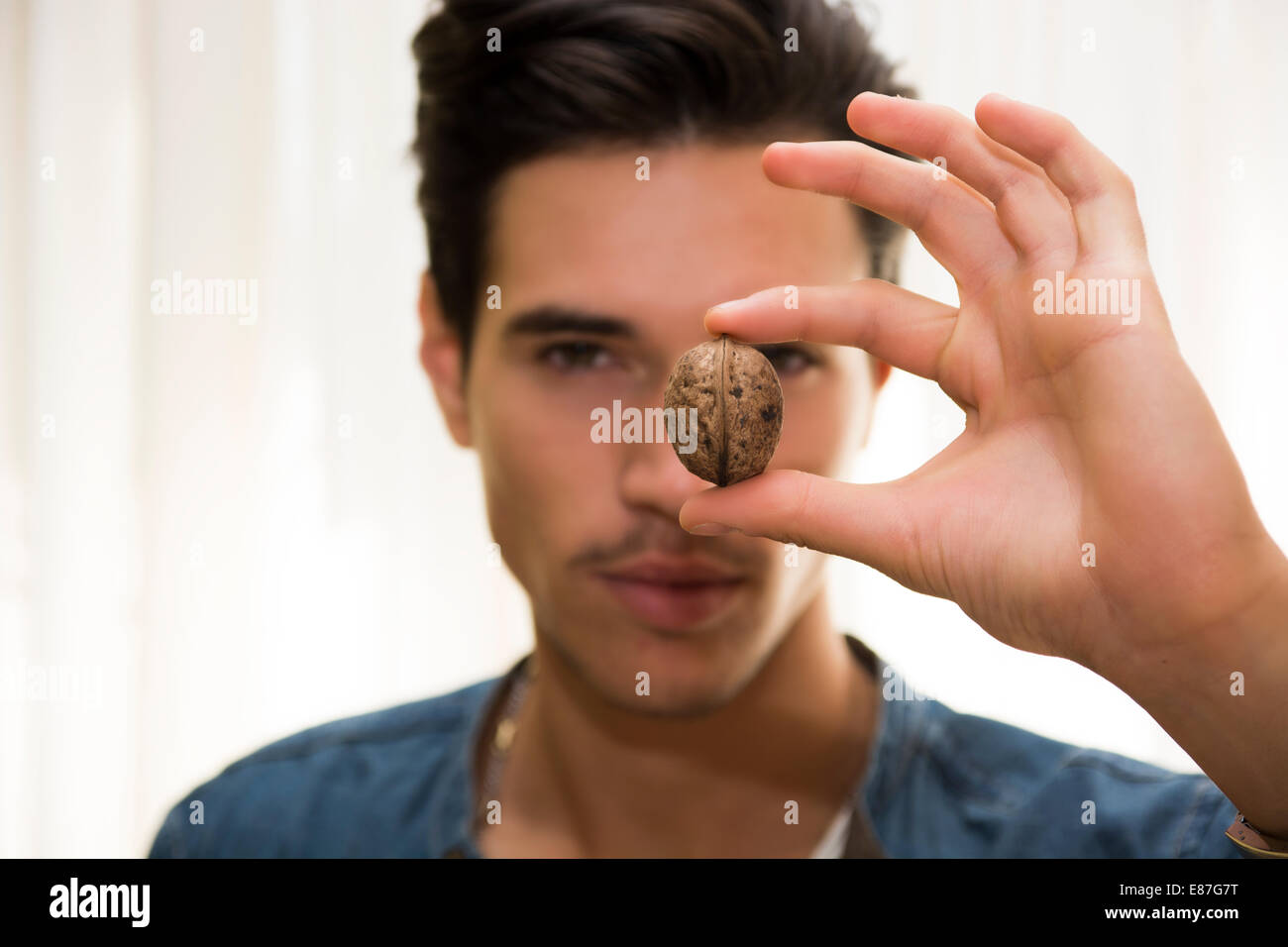 Young man holding a large delicious nut in his hand, focus to the fruit ...