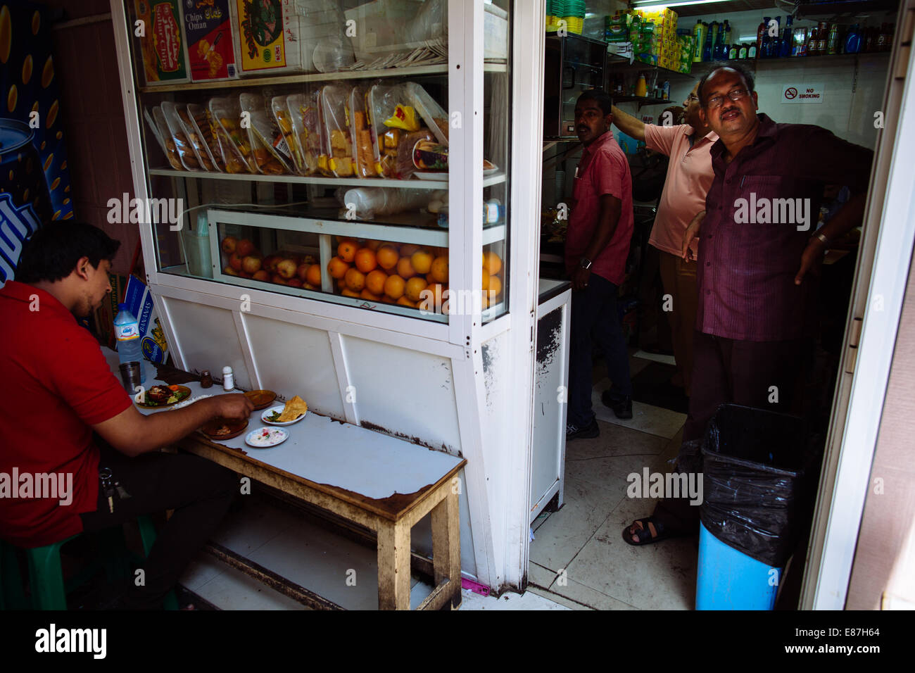People eating in a small food shak in the streets of Deira Gold Souk ...