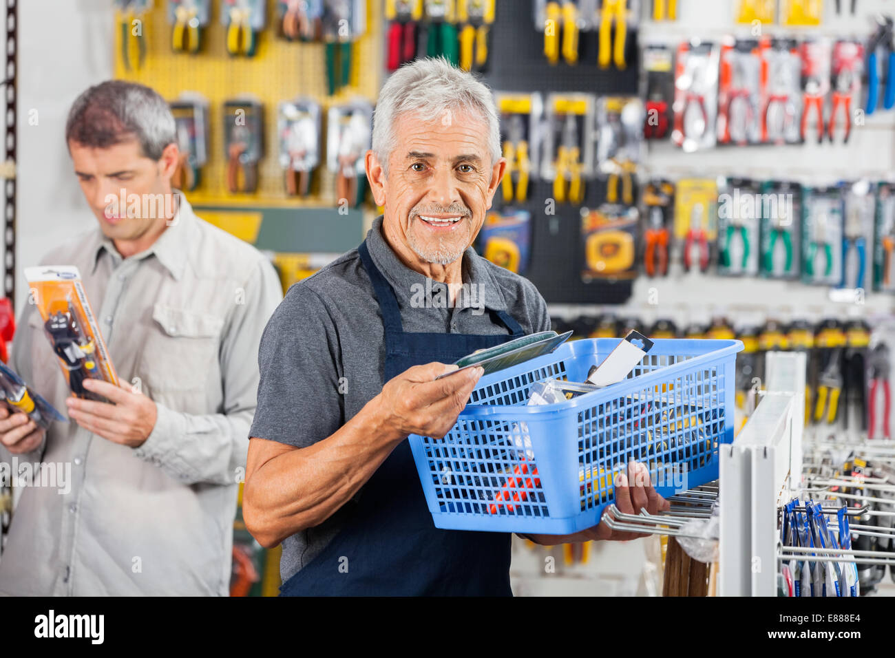 Salesman Holding Tools Basket At Hardware Store Stock Photo - Alamy