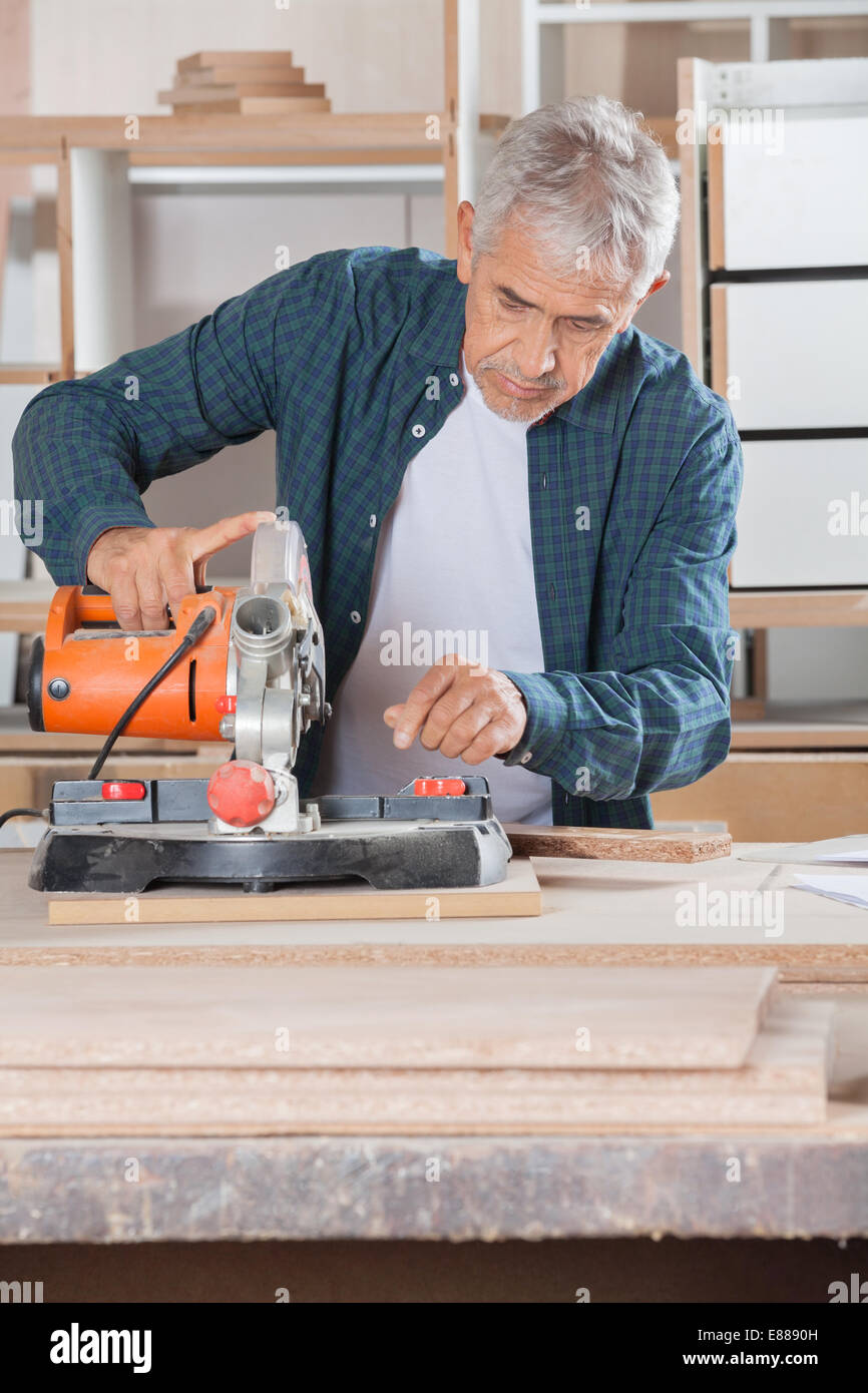 Carpenter Using Power Tool On Wood In Workshop Stock Photo - Alamy