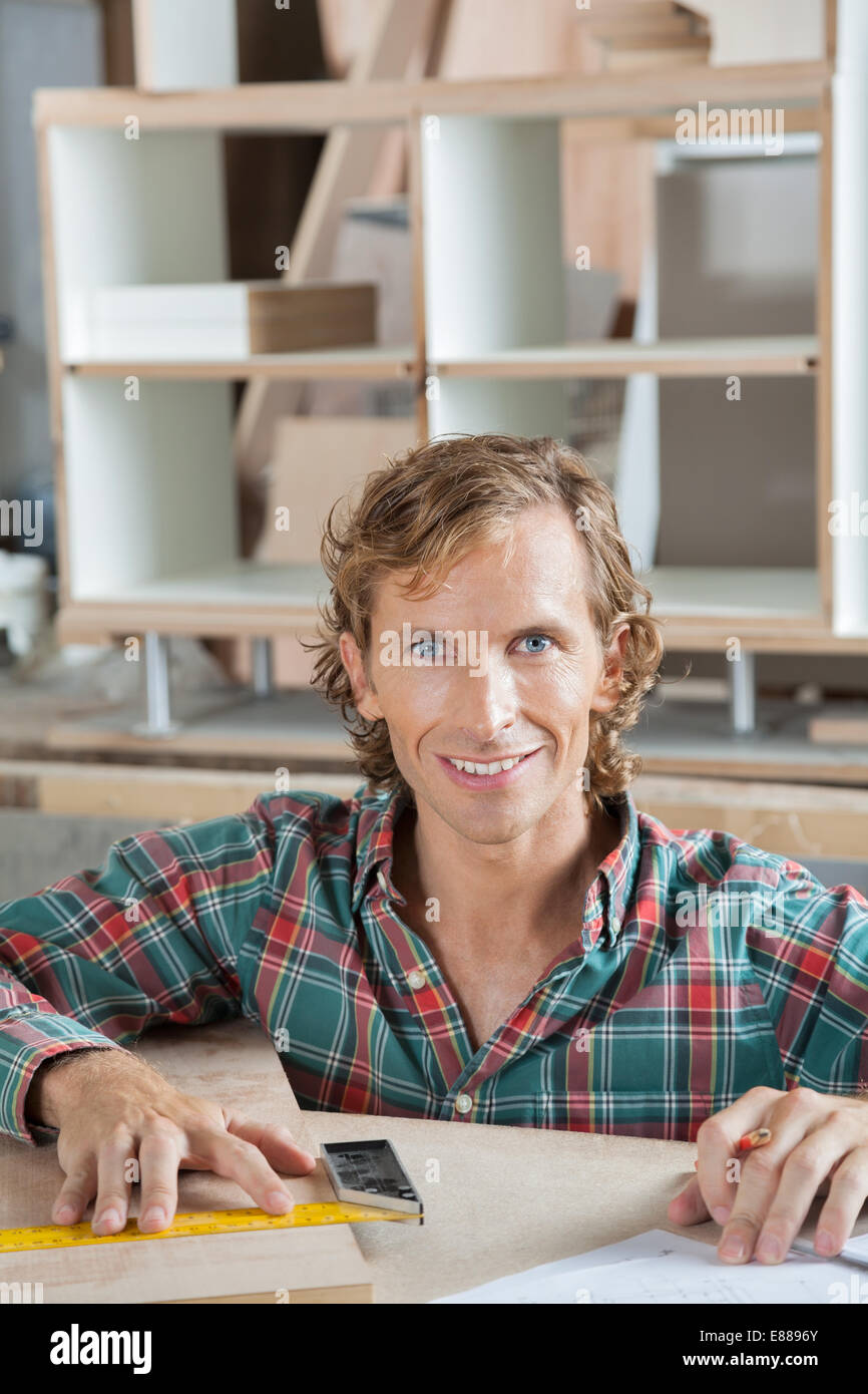 Confident Carpenter Smiling At Workbench Stock Photo - Alamy