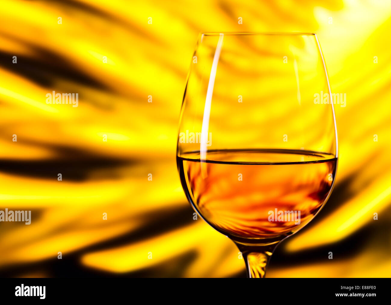 glass with white wine on yellow background Stock Photo - Alamy
