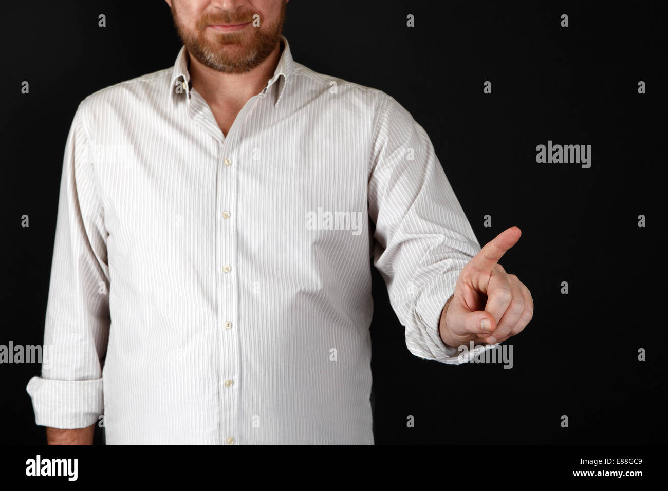 Man pointing at something in front of a black background Stock Photo ...